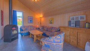 Um quarto acolhedor com um conjunto de sofás, um armário de madeira e uma lareira.