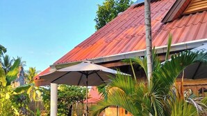 Uma área à beira da piscina com espreguiçadeiras e guarda-sóis.