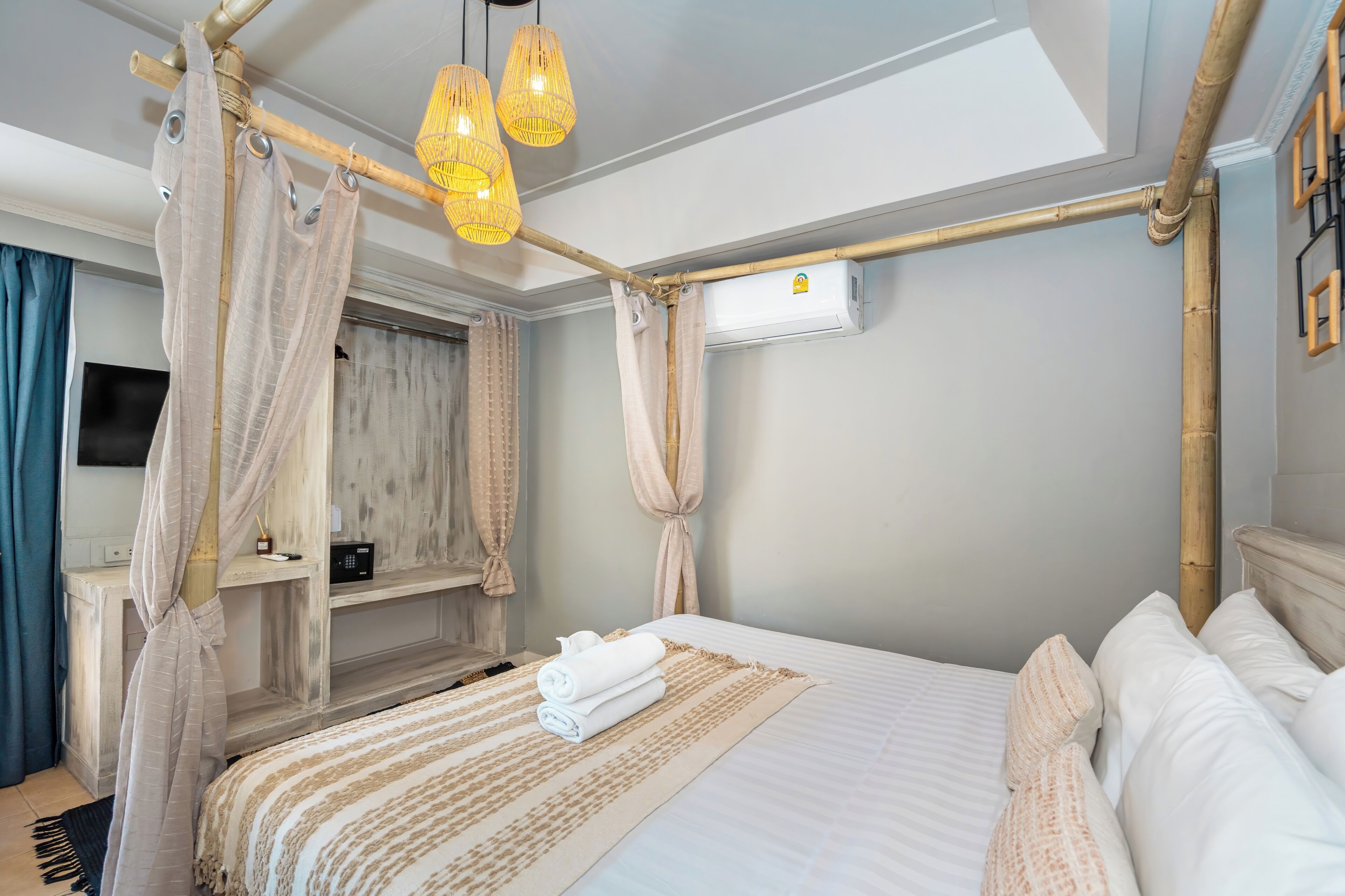 Quarto com uma cama, televisão, prateleira e janela.