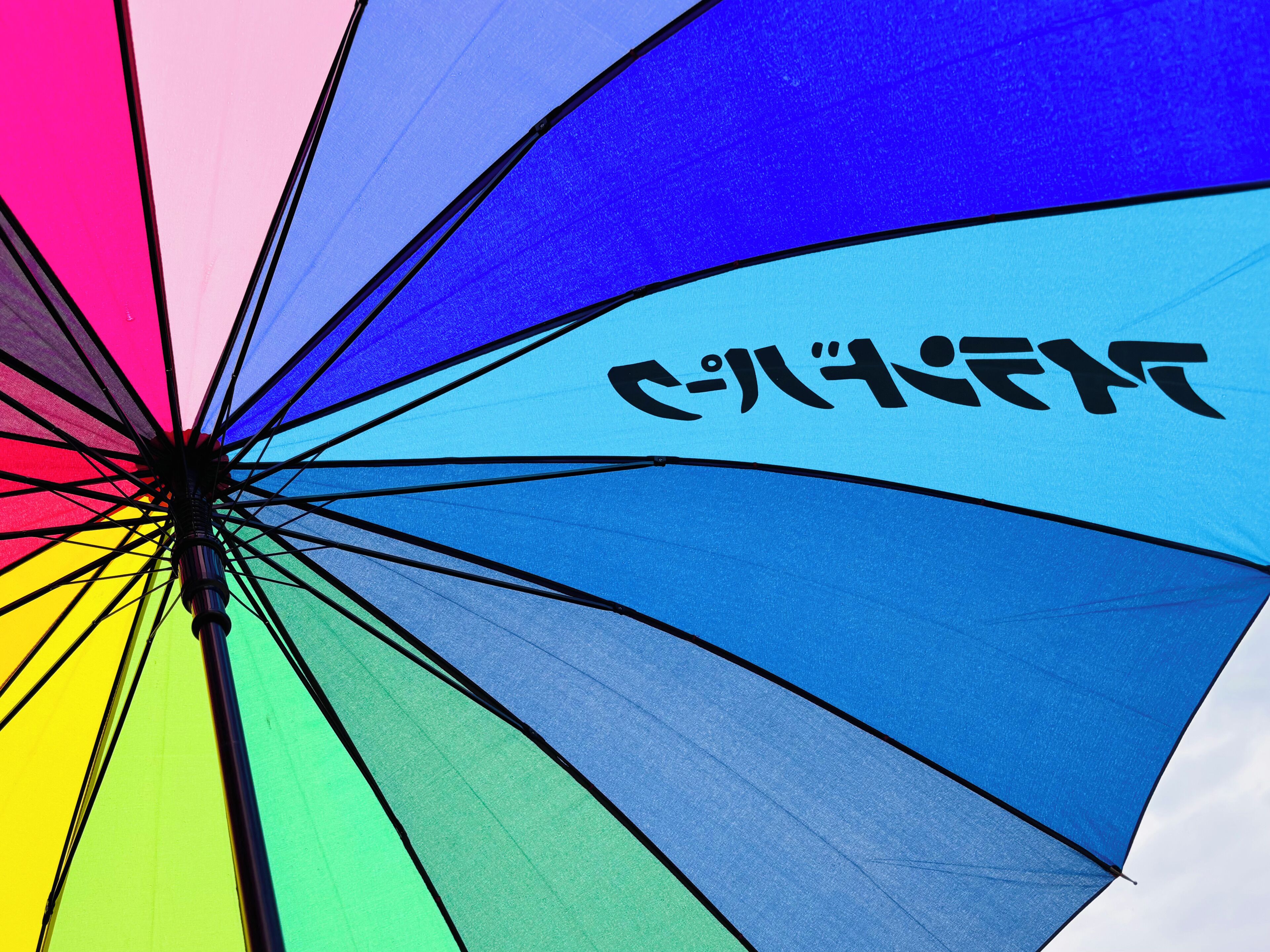 Um guarda-chuva colorido com um logotipo visível.