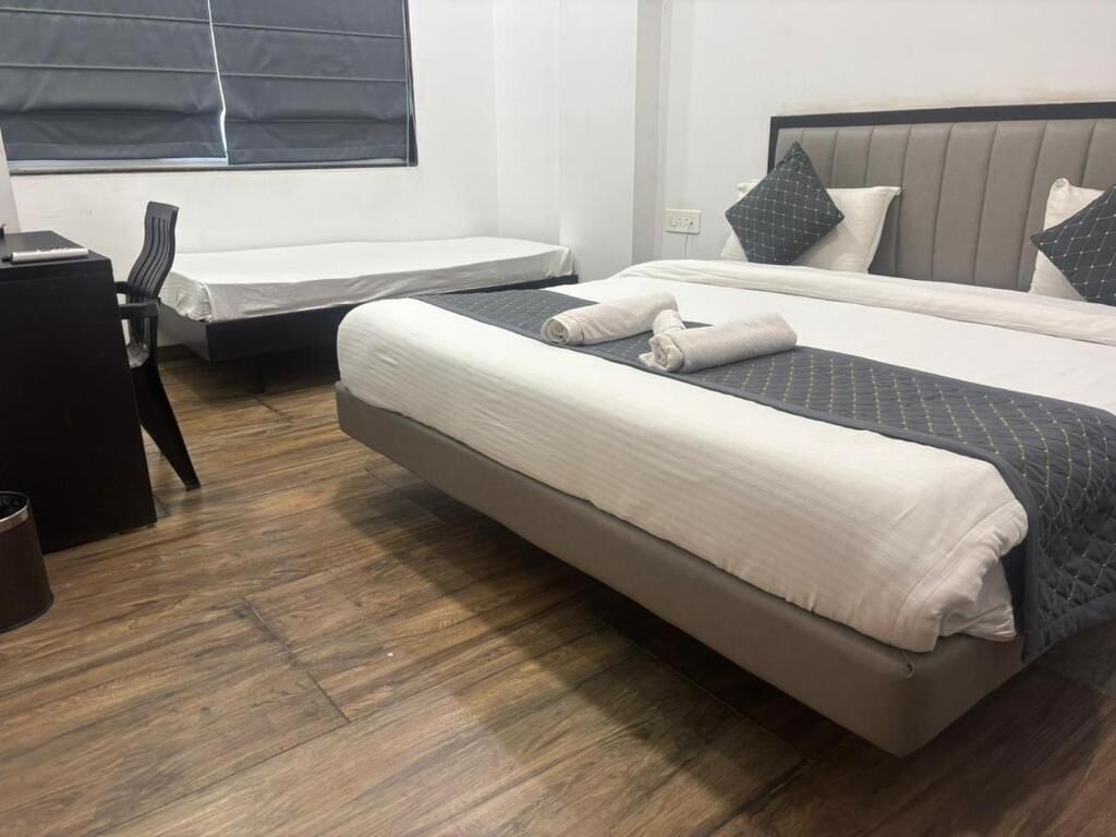 Quarto de hotel com uma cama grande, uma escrivaninha e uma cadeira.