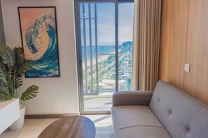 Apartamento família, sacada, vista para o mar | Área de estar | Smart TV 55 polegadas com canais a cabo, filmes pagos, smart speakers