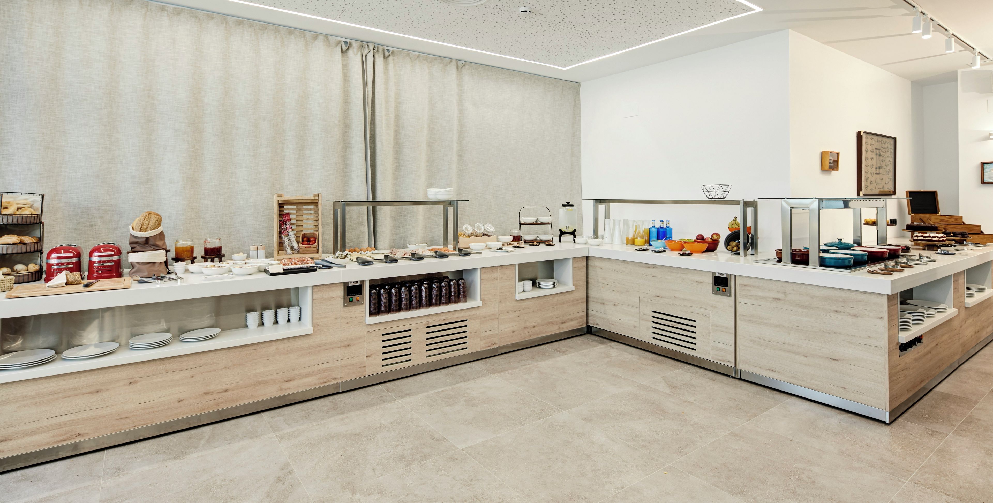 Disposição de buffet de café da manhã com diversos alimentos e bebidas.
