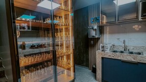 Cozinha moderna com adega embutida, dispensador de água e pia de aço inoxidável.