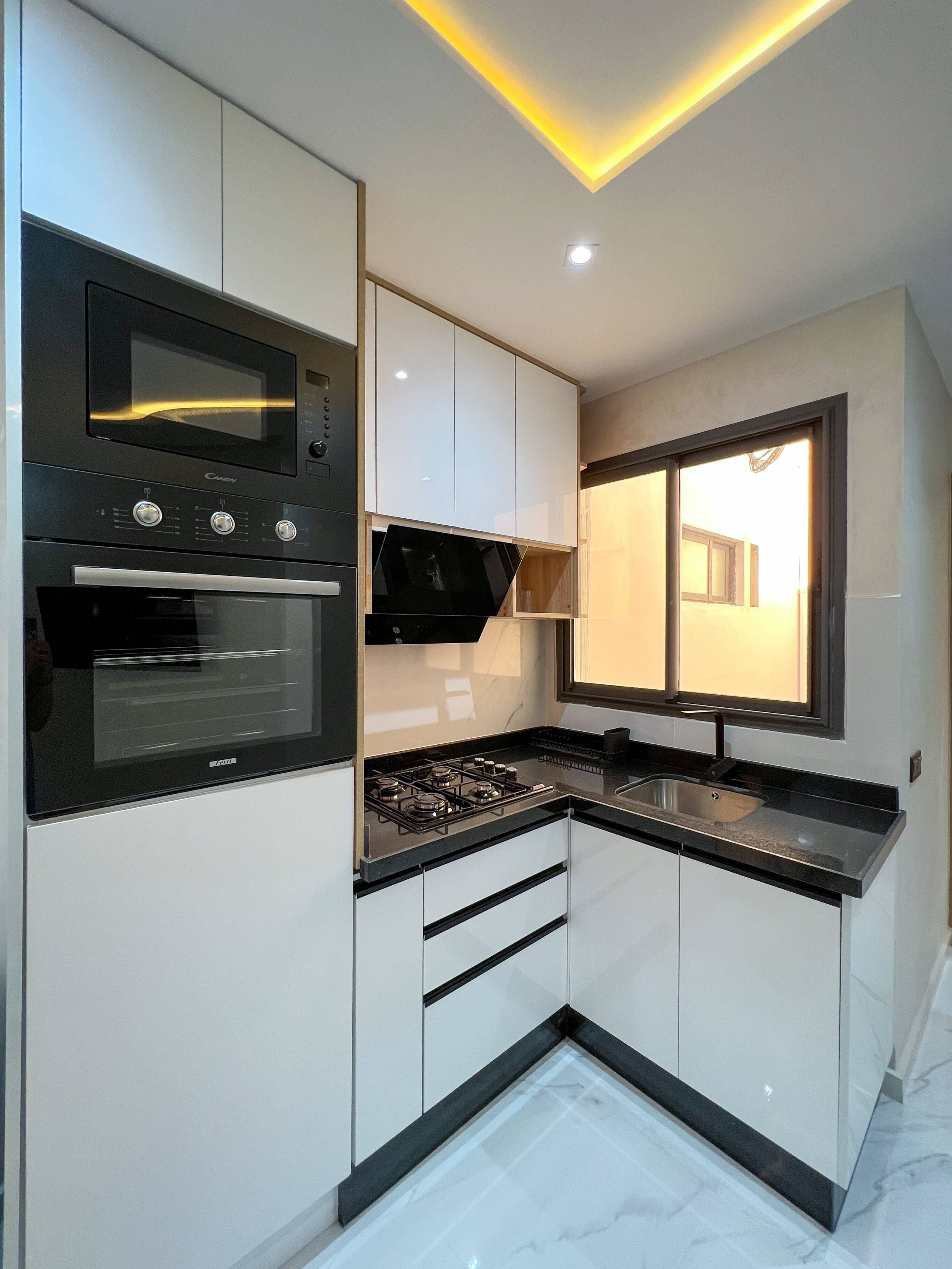 Uma cozinha moderna com eletrodomésticos embutidos, uma janela grande e um design elegante.