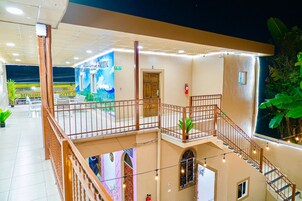 Um hotel com varanda, um mural e uma escadaria.