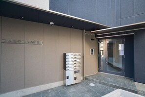 Entrada de um edifício moderno, com um compartimento para correspondência e uma porta.