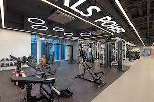 Uma academia com diversos equipamentos de ginástica, incluindo esteiras, aparelhos de musculação e pesos livres.