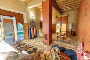 Quarto tradicional com teto de madeira, um tapete grande e um armário de madeira.