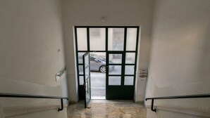 Escadaria que leva a um carro estacionado em frente a uma porta de vidro.