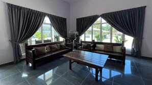 Um quarto espaçoso com uma janela grande, um banco de madeira e um sofá com almofadas.