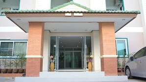 Um edifício com telhado de telhas, entrada de vidro e fachada de tijolos.
