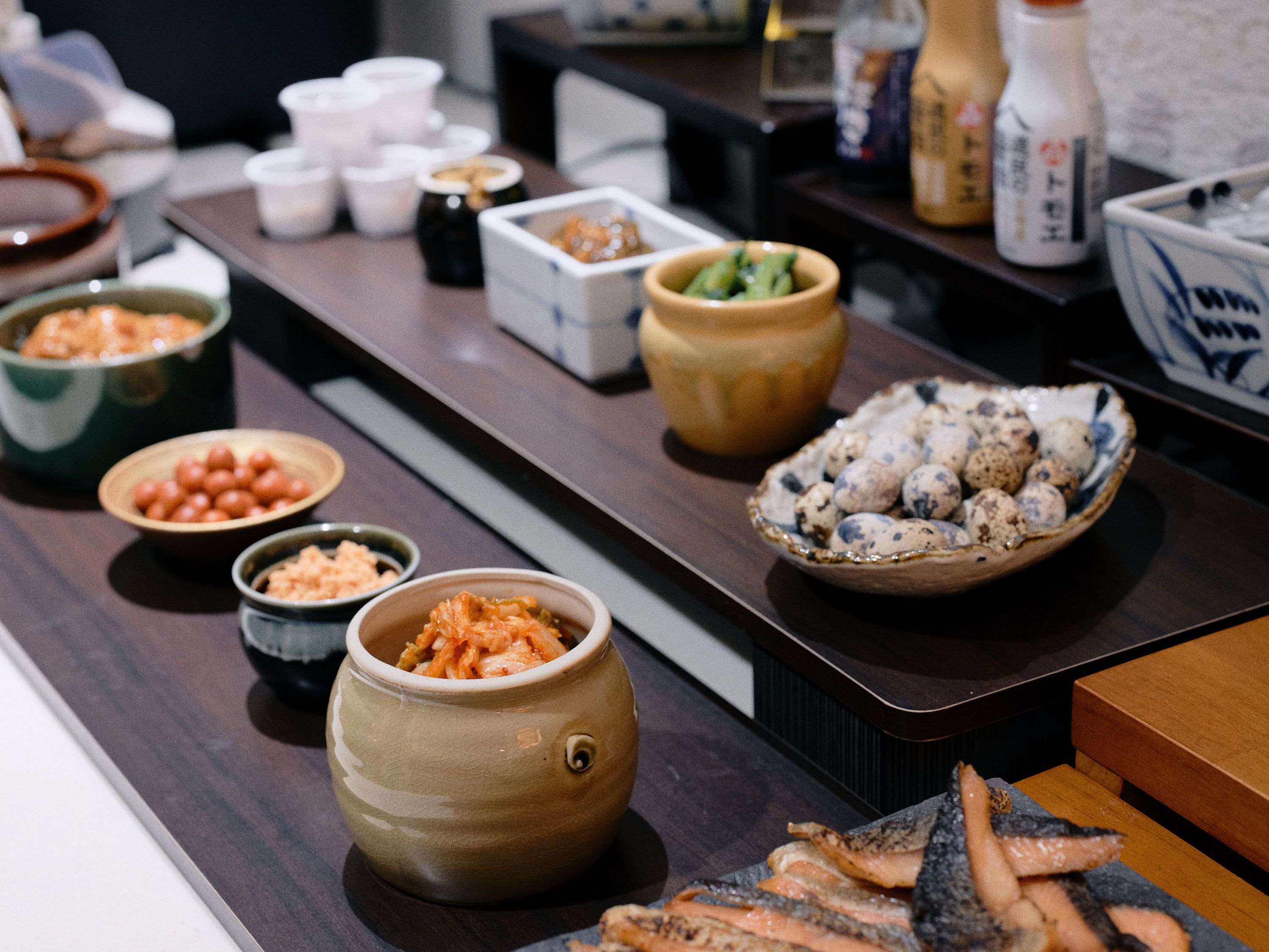 Uma mesa de buffet com diversos alimentos e recipientes.