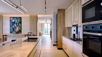 Uma cozinha moderna com ilha central, eletrodomésticos de aço inoxidável e uma janela grande.