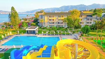 Um hotel com piscina, toboáguas e vista para o mar.