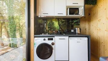 Cozinha compacta com máquina de lavar, lava-louças e micro-ondas.