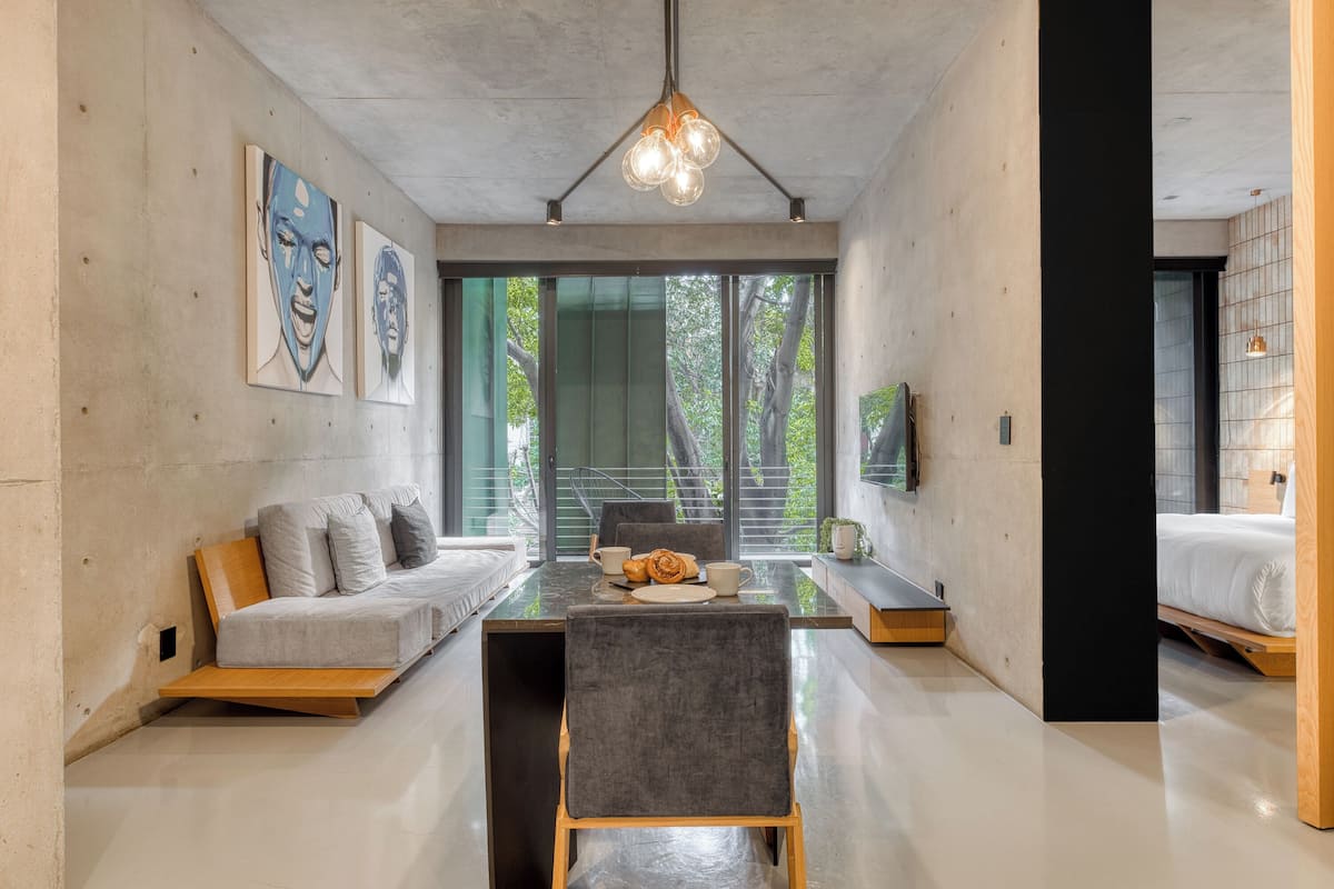 Um interior moderno com área de refeições, sofá e obras de arte nas paredes.