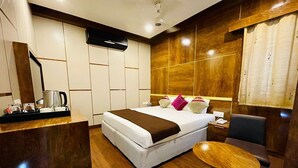 Quarto de hotel moderno com uma cama grande, mesa de cabeceira e uma pequena mesa redonda.
