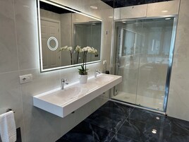 Suite Queen Deluxe | Banheiro | Chuveiro, secador de cabelo, chinelos, toalhas de banho