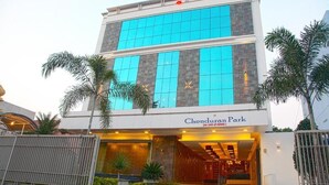 Um hotel moderno com entrada imponente, placa com o nome e escadaria visível que dá acesso ao saguão.