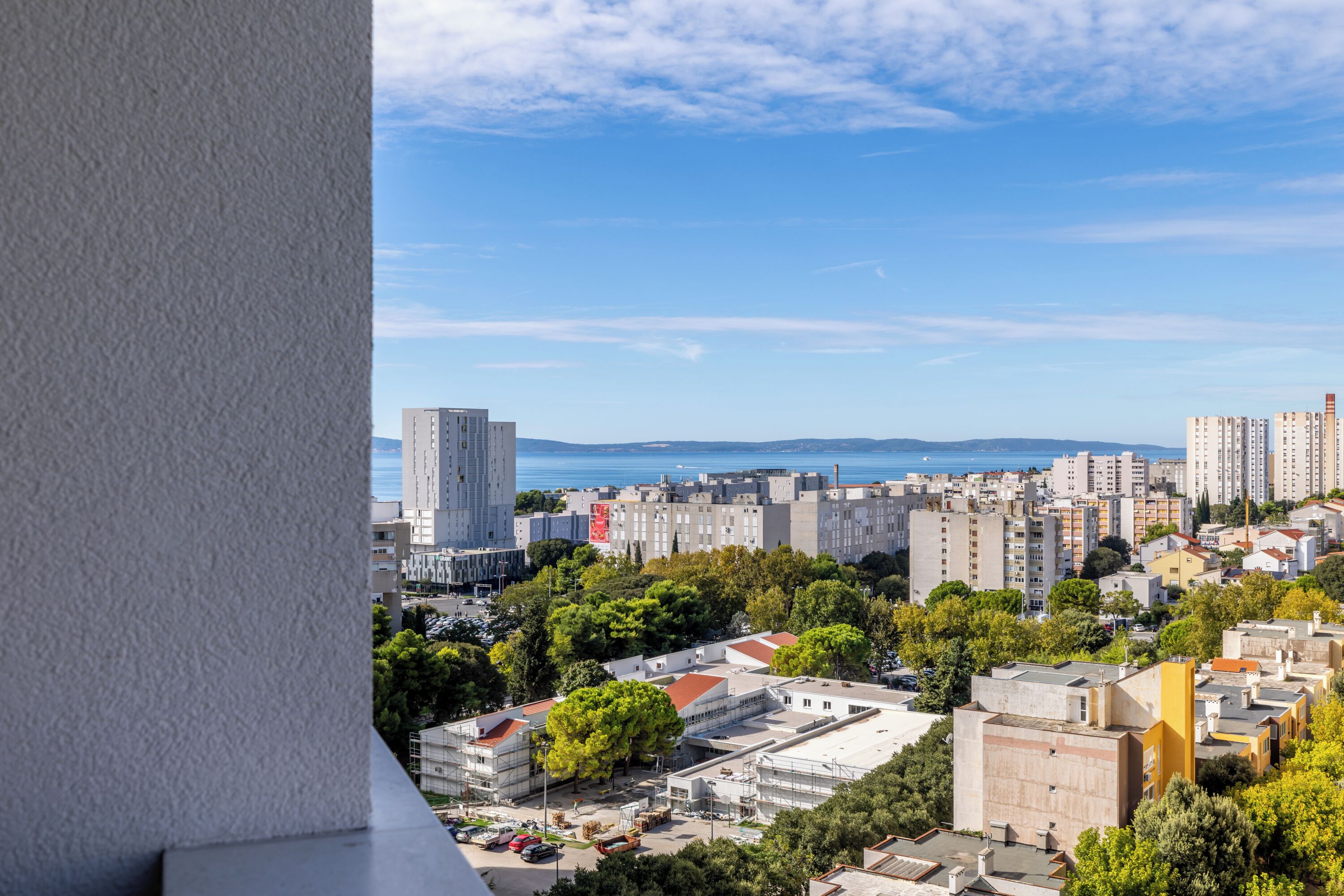Um edifício alto com vista para a paisagem urbana e o mar.