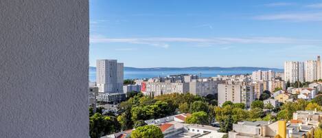 Um edifício alto com vista para a paisagem urbana e o mar.
