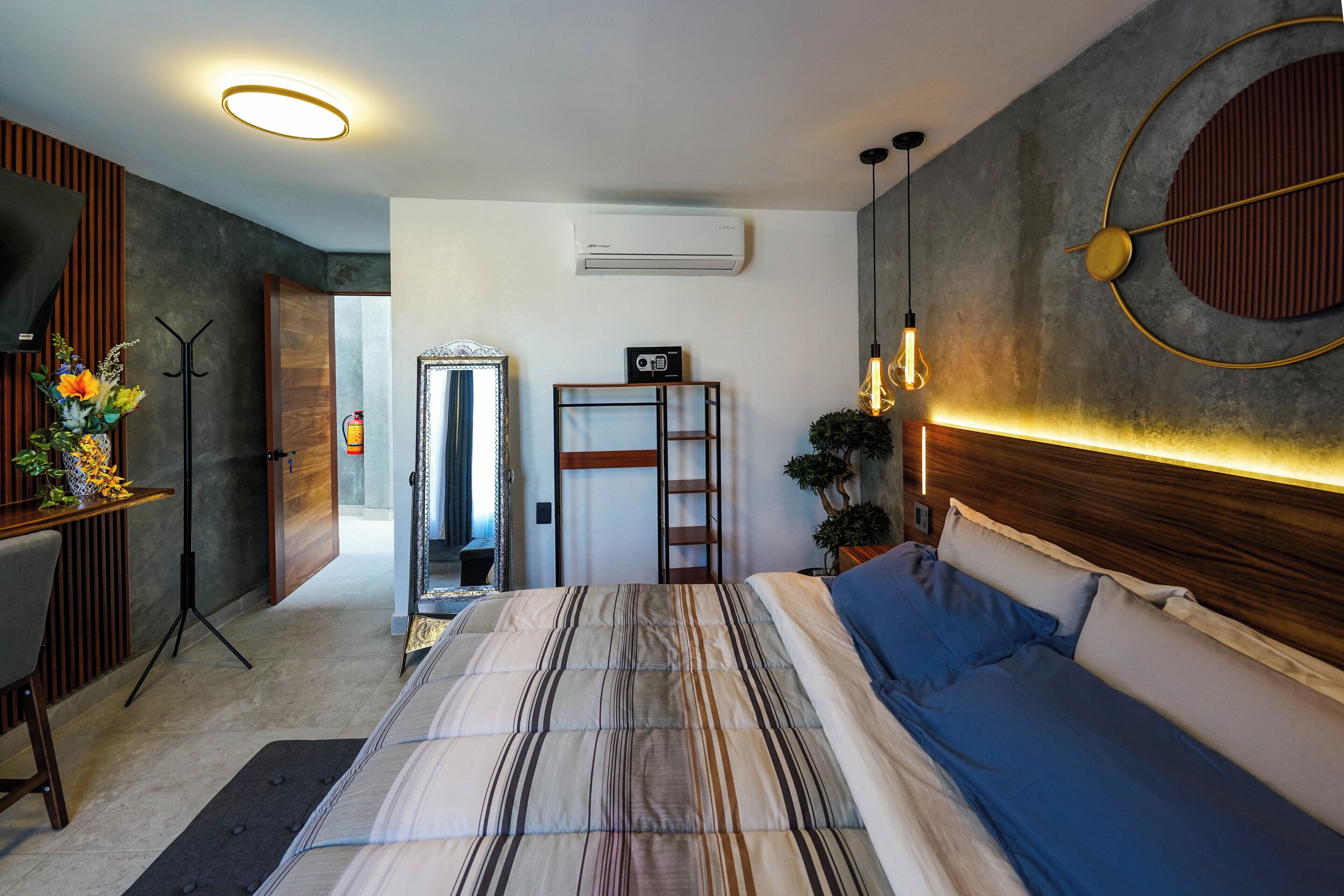 Quarto moderno com cama grande, escrivaninha e guarda-roupa.