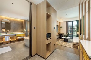 Casa de banho de hotel moderna com banheira, toucador e espelho grande.