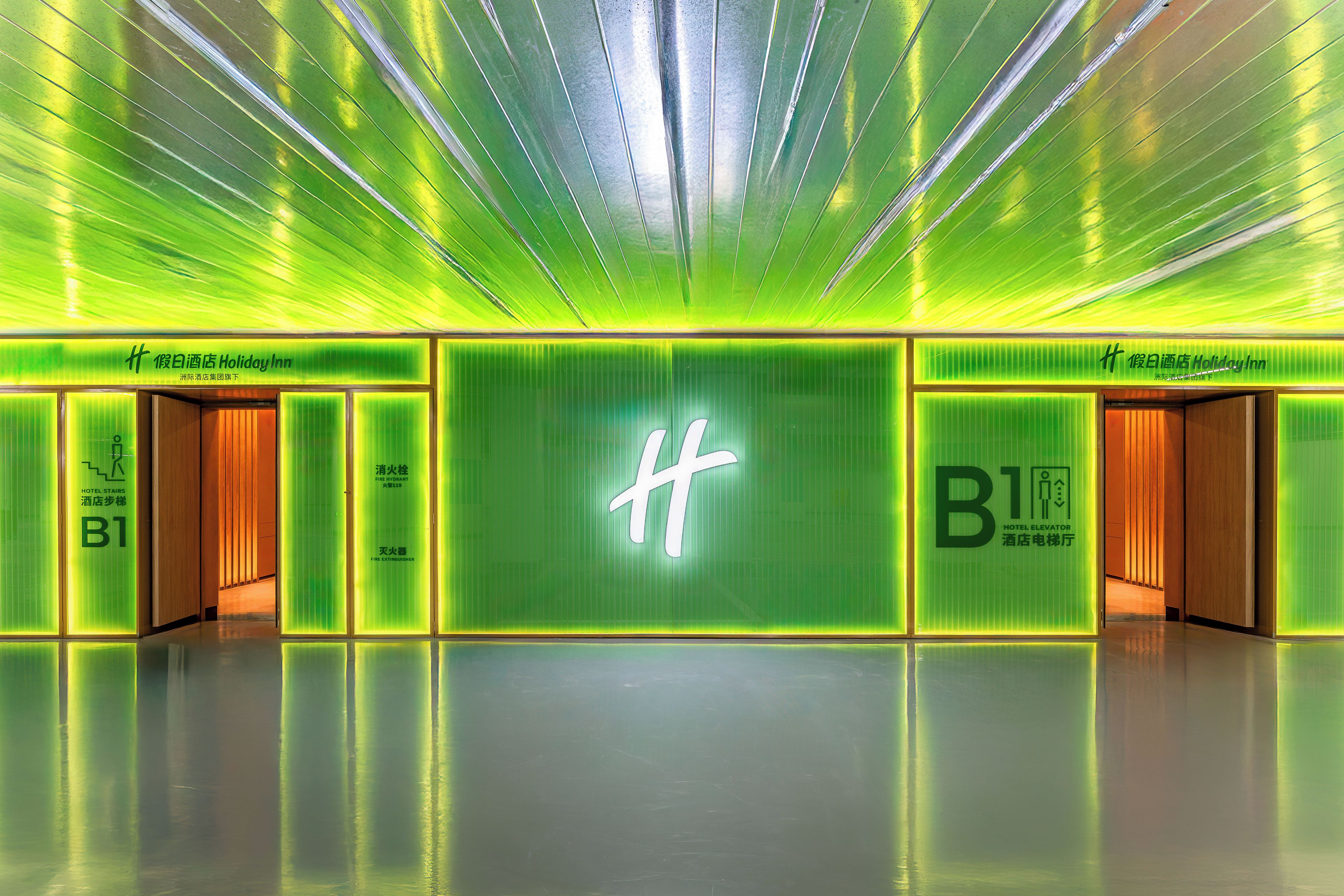 Um saguão de hotel com design moderno, apresentando um símbolo # proeminente na parede, uma placa de elevador B1 e uma placa de segurança contra incêndio.