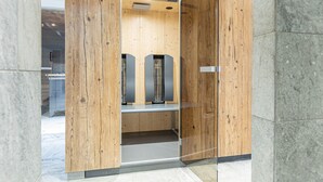 Um elevador moderno com painéis de madeira e interior metálico.