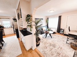 Espaço compacto com cozinha compacta, área de refeições e sala de estar com sofá e mesa de centro.