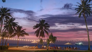 Na praia, praia de areia branca, espreguiçadeiras, guarda-sóis de praia