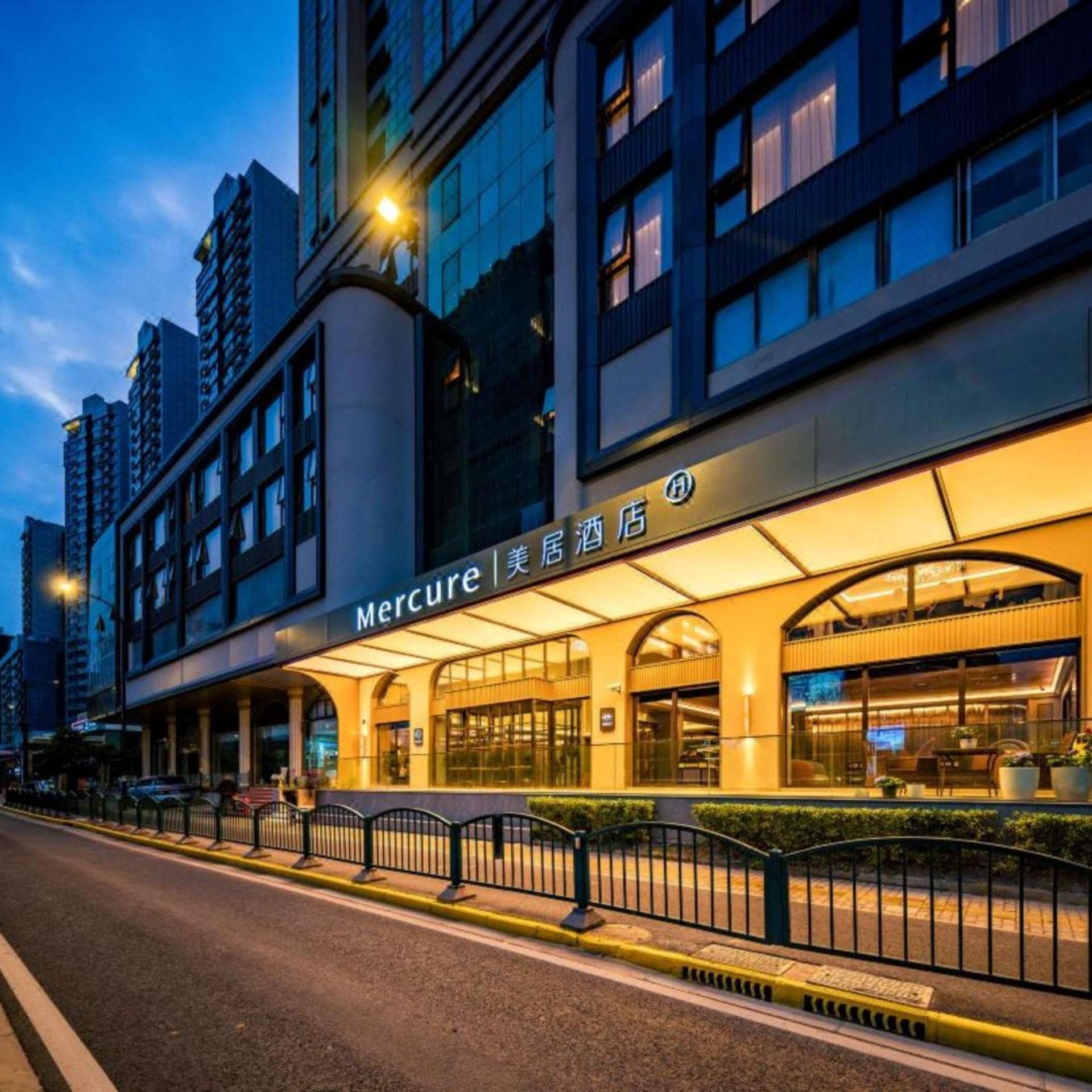 Um hotel com fachada moderna, entrada imponente e fachada bem iluminada.