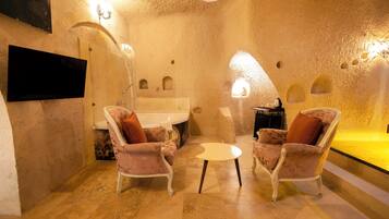 Suite Deluxe | Sala de estar | Televisor de 120 de cm com canais via satélite, lareira, piso aquecido