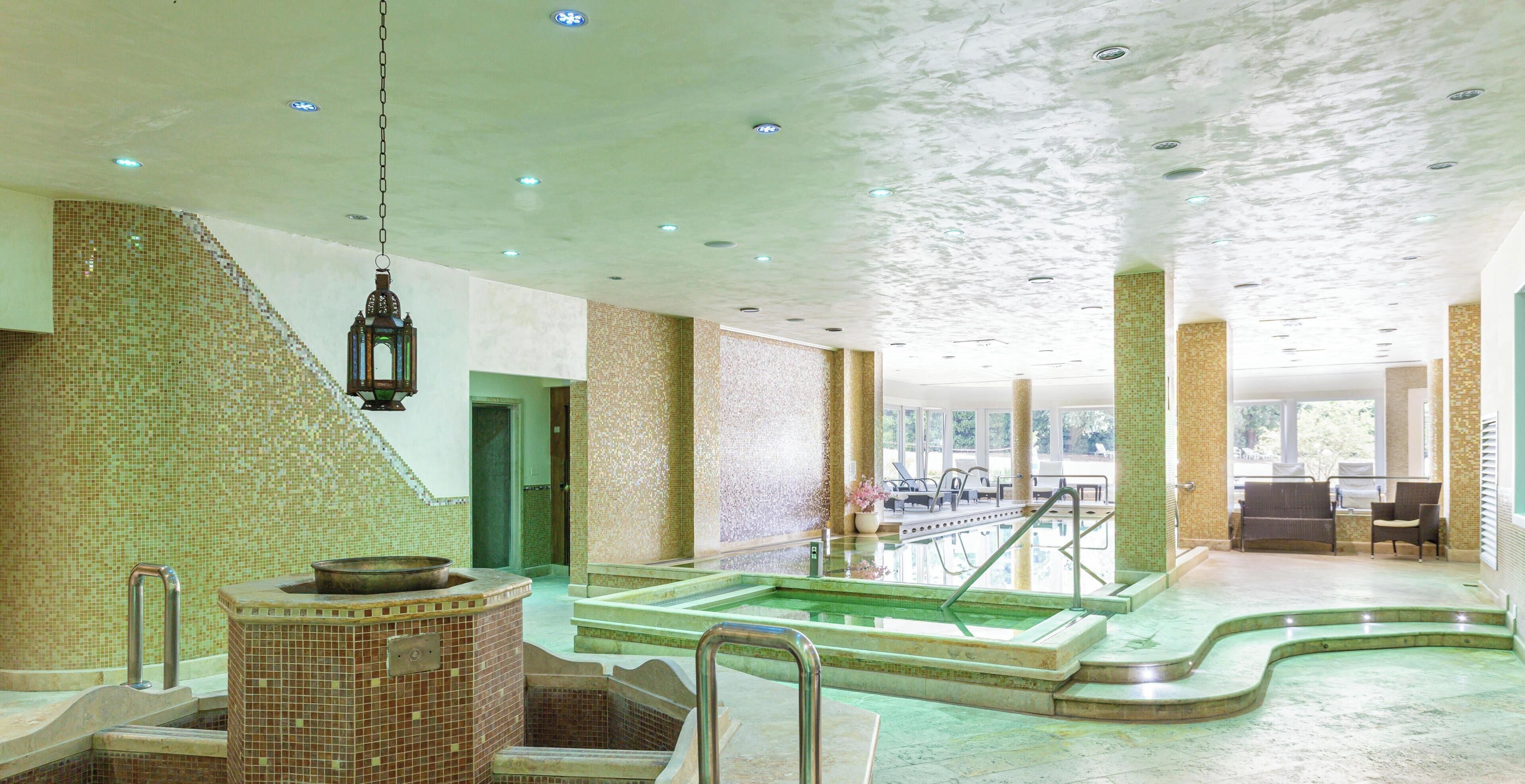 Uma área de spa com hidromassagem, espaço para sentar e escada que leva a um andar superior.