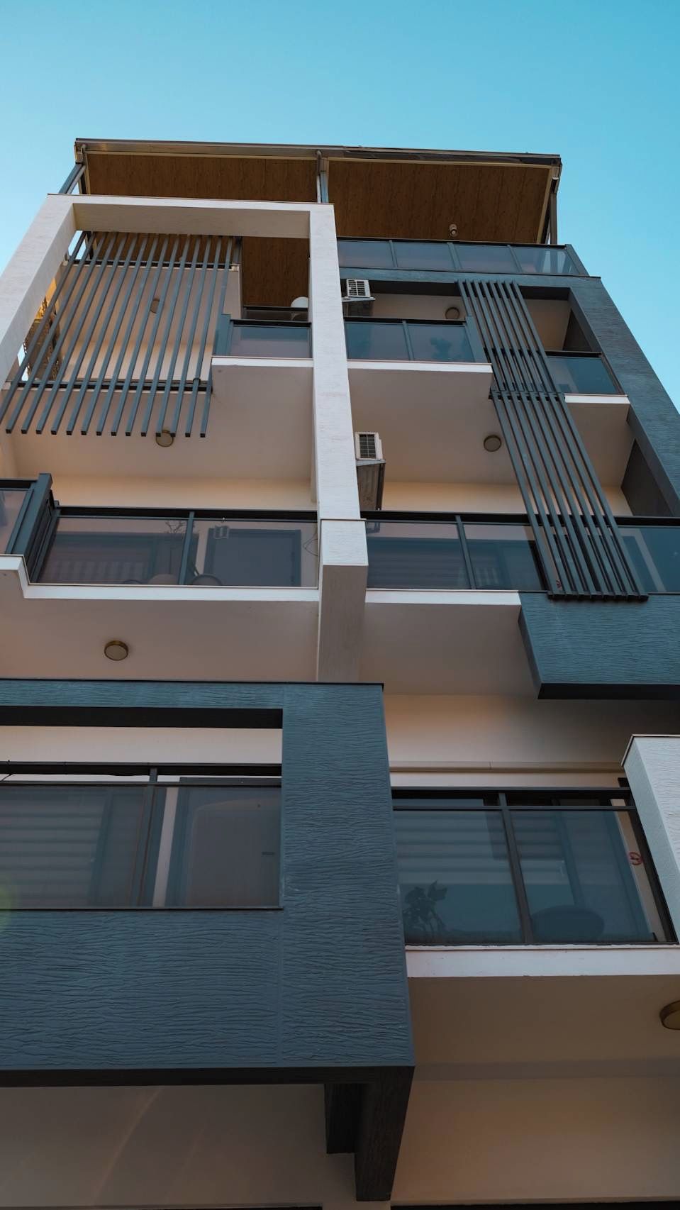 Um edifício de vários andares com design arquitetônico moderno, com grandes janelas e sacadas.