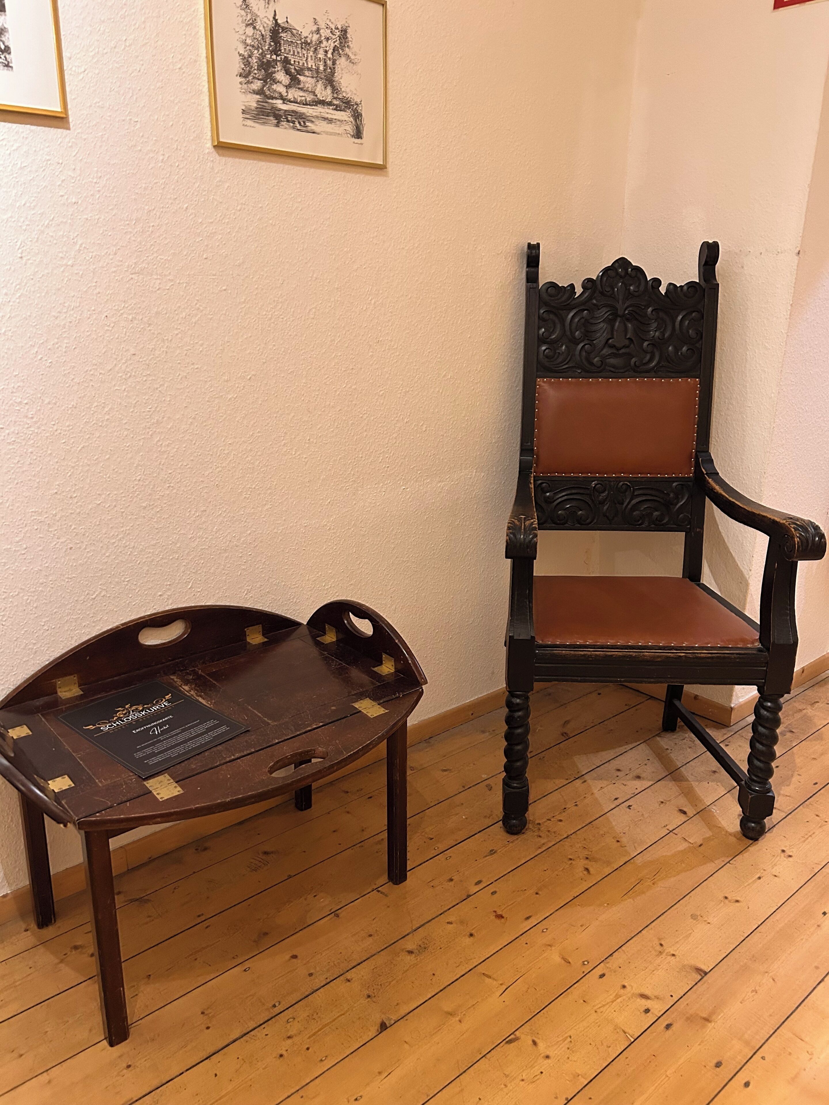 Um banco de madeira com uma placa e uma cadeira de madeira escura com almofadas de couro.