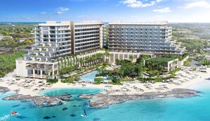 Um hotel grande com vários andares, piscina e área de praia.