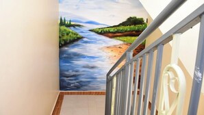 Uma escadaria com um mural representando uma paisagem fluvial.