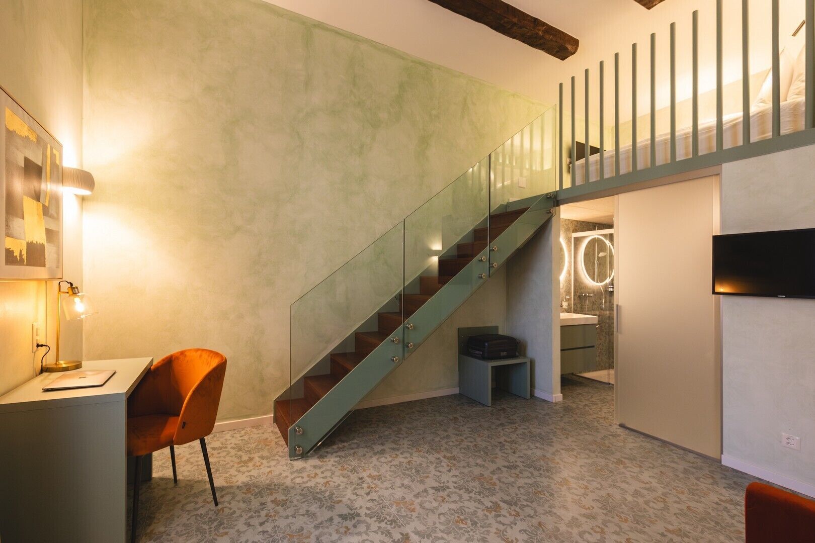 Um interior moderno com escada, escrivaninha e cadeira.