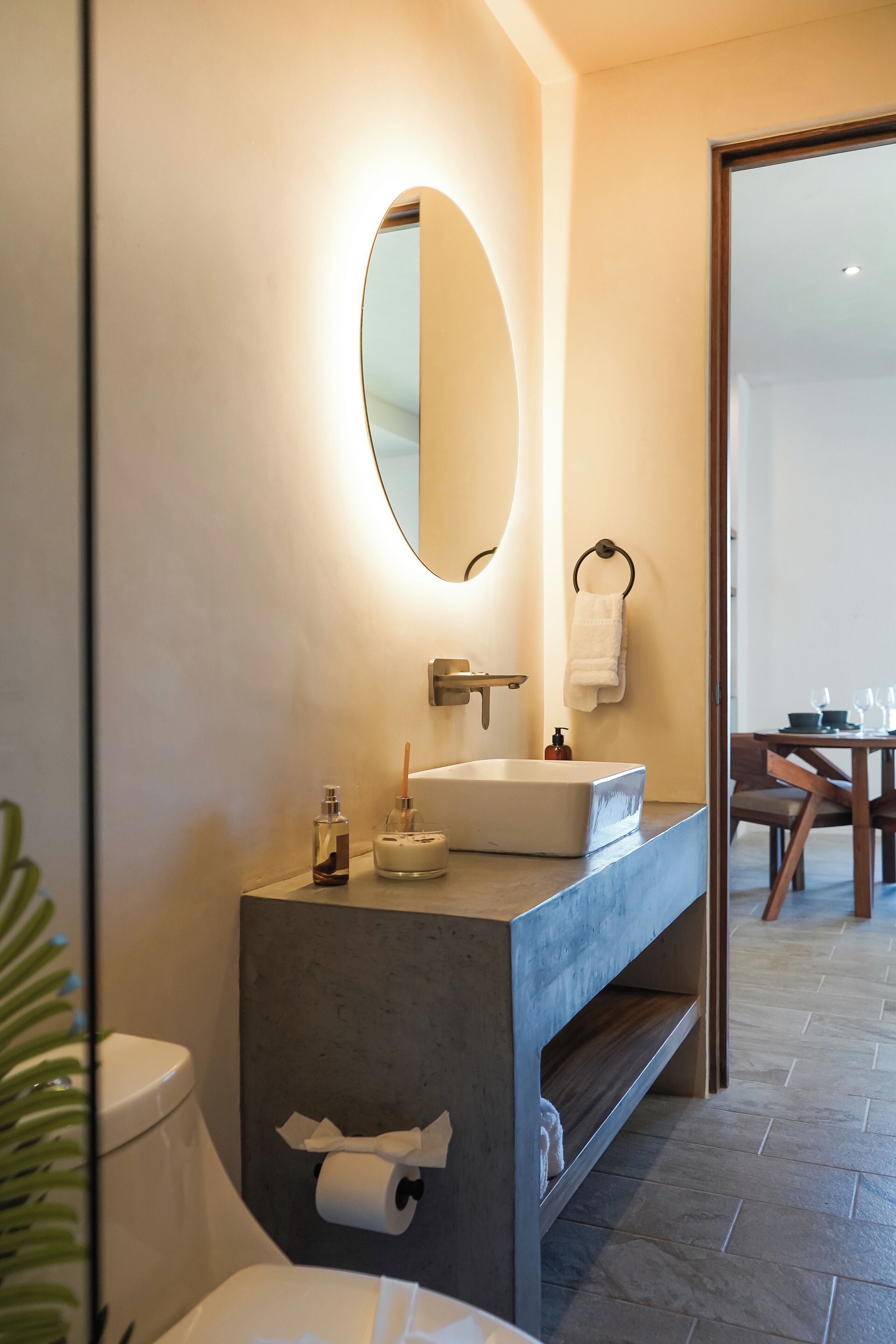 Uma casa de banho moderna com um espelho grande, uma pia e uma sanita.