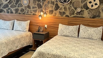 Quarto com duas camas, parede de pedra e pratos decorativos de tecido.