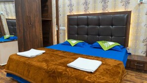 Quarto de hotel com uma cama grande, um guarda-roupa e um espelho.