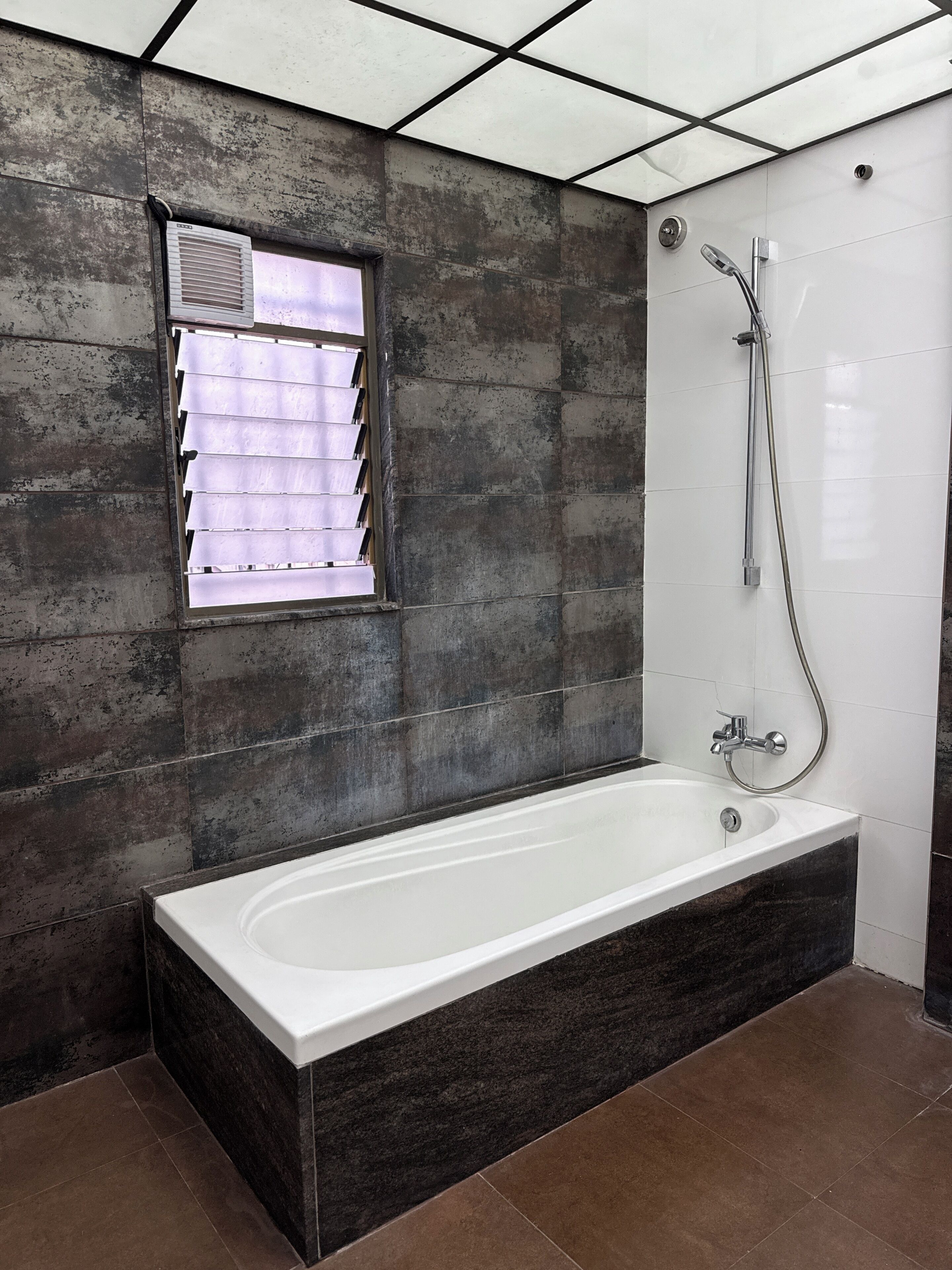 Uma casa de banho moderna com banheira, chuveiro e janela com persianas.