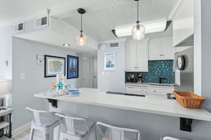 Condo com design assinado, 2 quartos, cozinha, vista para a praia | Cozinha privada | Geladeira, micro-ondas, fogão, cooktop