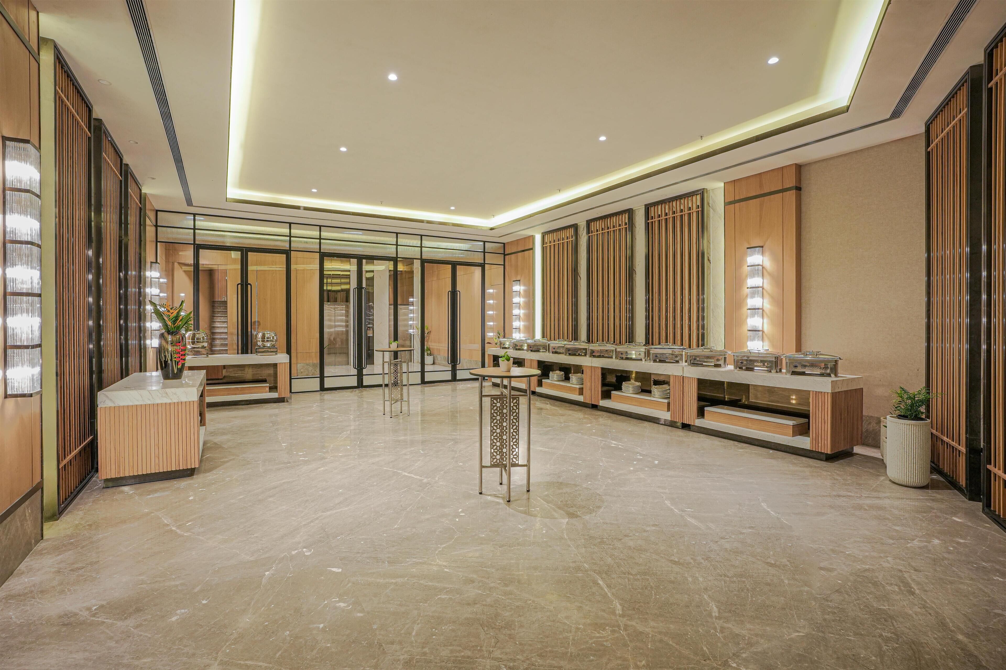 Um hall amplo com piso de mármore, balcão de recepção e área de estar com um balcão comprido.