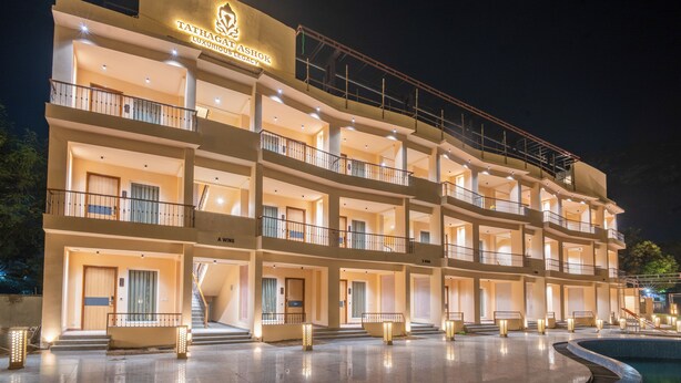 Um hotel com vários andares e uma placa de destaque com a inscrição "TATHAGAT ASHOK LUXURIOUS LEGACY".