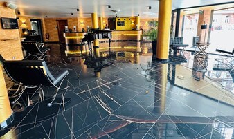 Um lobby com balcão de recepção, um piano e área de estar com cadeiras.