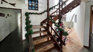 Escada de madeira decorada com uma guirlanda e uma colagem de fotos na parede.