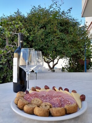 Uma mesa com uma garrafa de vinho, copos e um prato de comida.